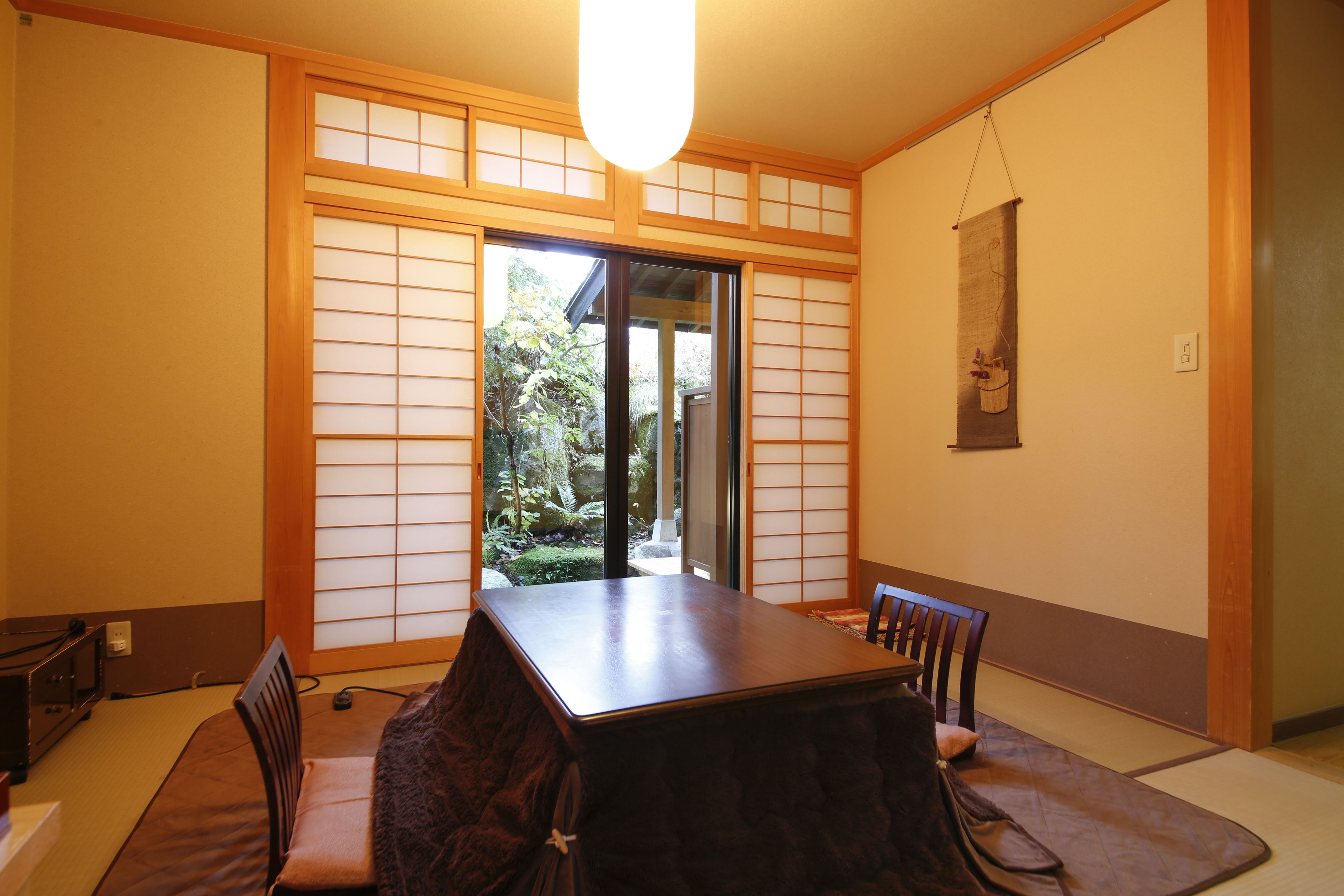 Um quarto japonês tradicional com tatames, uma mesa baixa e biombos shoji.