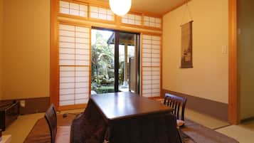 Um quarto japonês tradicional com tatames, uma mesa baixa e biombos shoji.