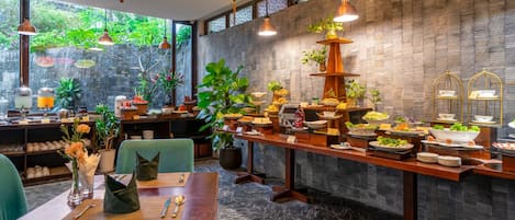 Um restaurante com um balcão comprido, várias luminárias pendentes e uma variedade de pratos expostos.