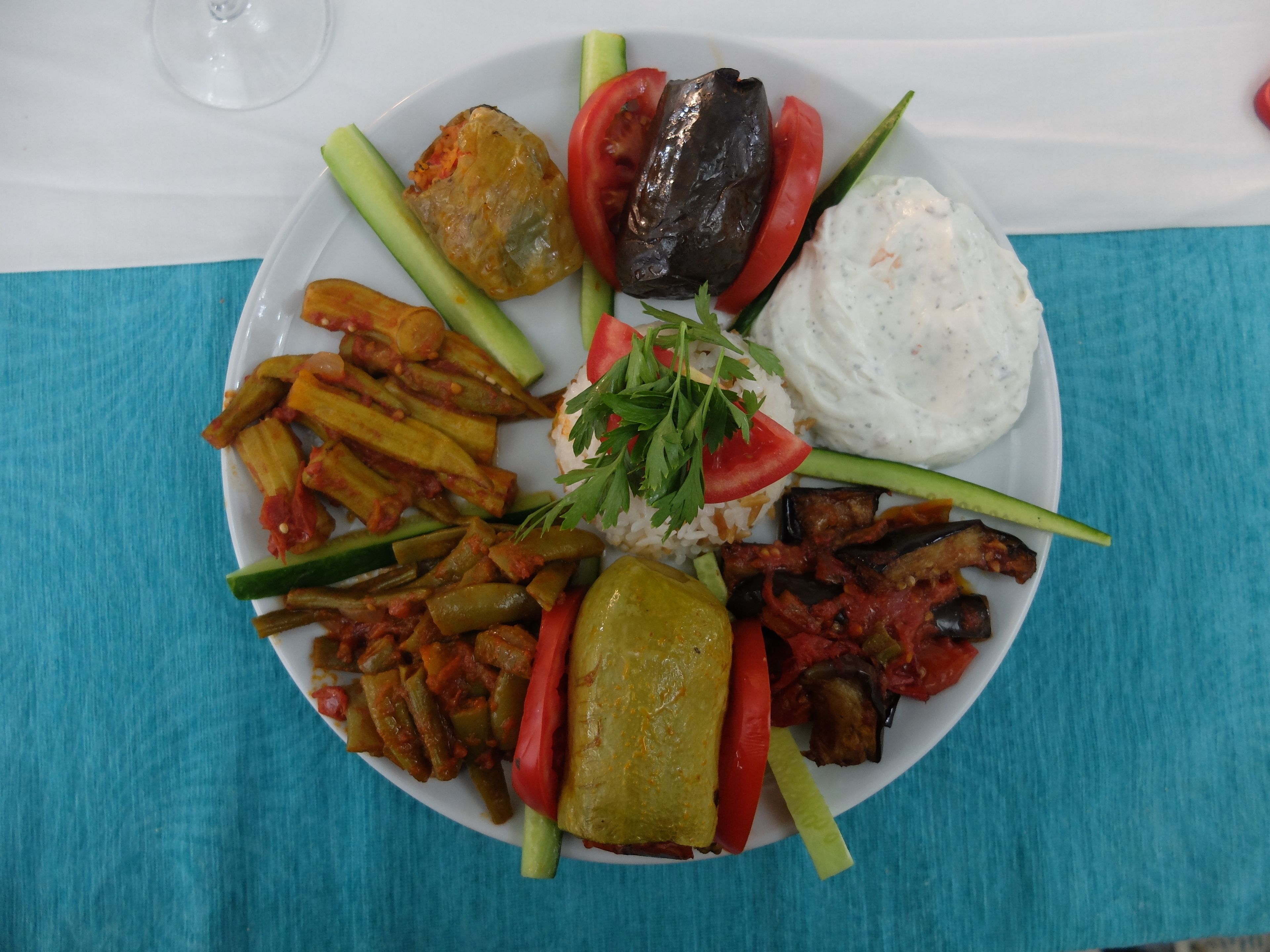 Prato de comida com legumes, carne, arroz e molho.