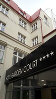 Um edifício com uma placa que diz "HOTEL GARDEN COURT".