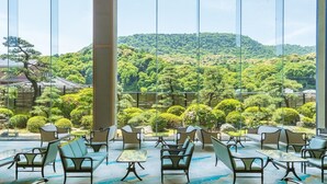 Terraço com área de estar ao ar livre e vista para uma paisagem verde exuberante.