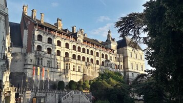 Um edifício histórico com várias arcadas e uma torre imponente.