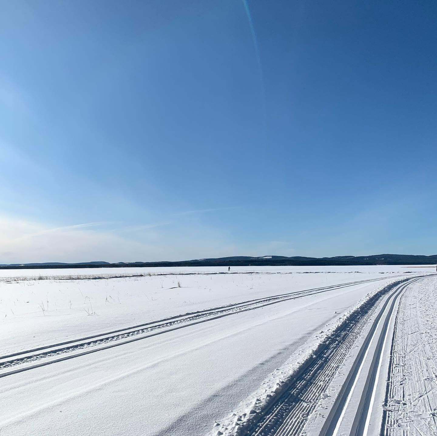 Uma estrada coberta de neve com marcas de pneus.
