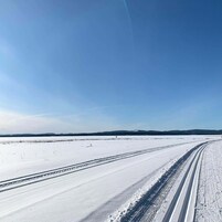 Uma estrada coberta de neve com marcas de pneus.