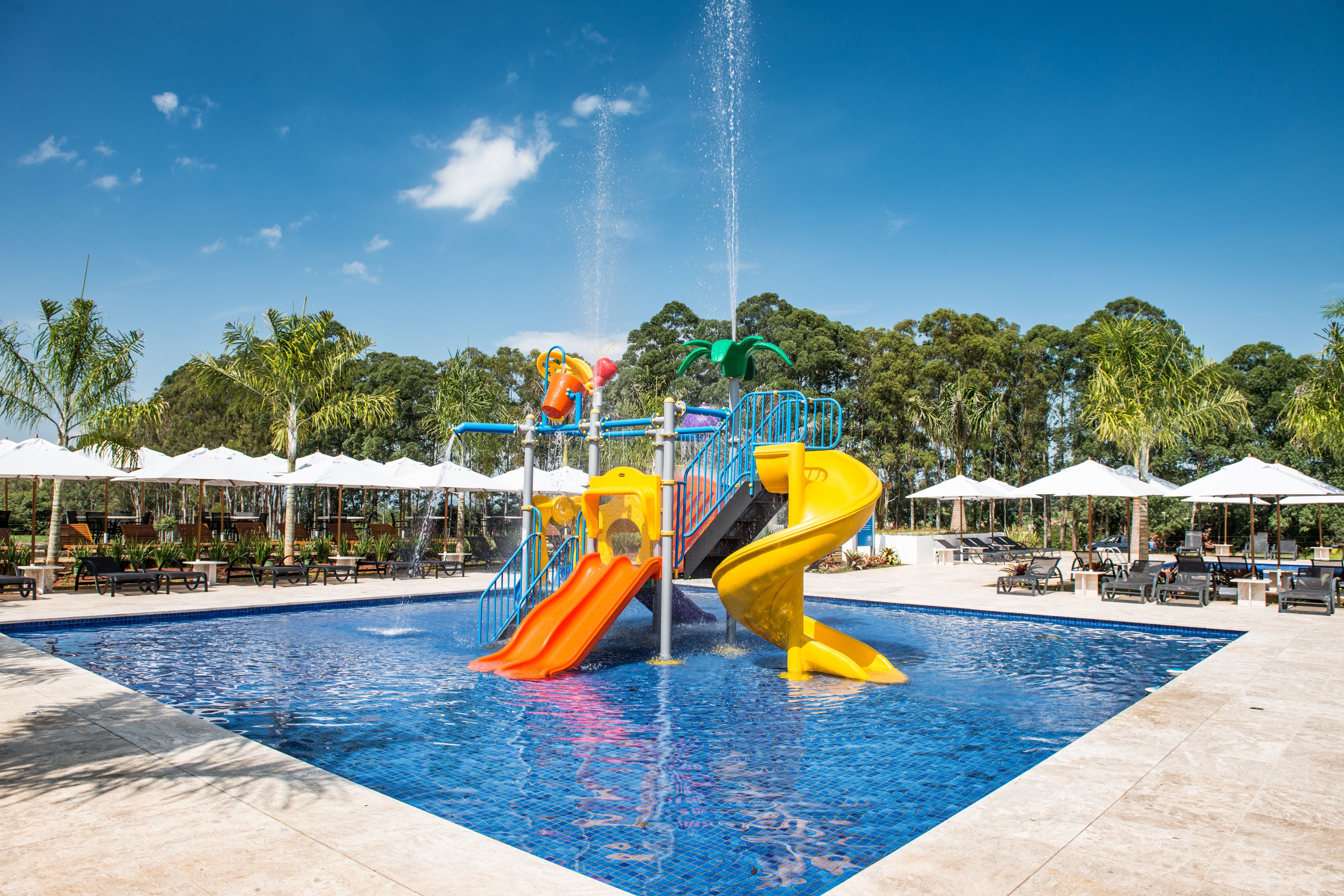 Piscina com escorregador e fonte.