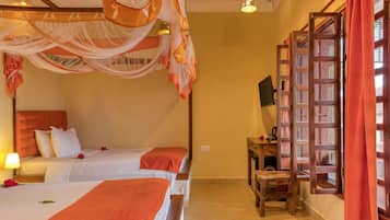 Quarto de hotel com duas camas, uma secretária de madeira, televisão e uma janela grande com cortinas.