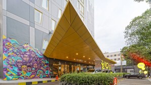 Um hotel moderno com um telhado triangular característico e um mural colorido na fachada.