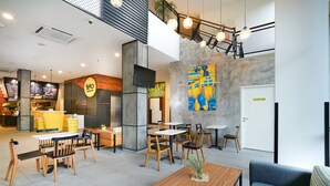 Um café moderno com móveis de madeira, um grande mural e uma escadaria.