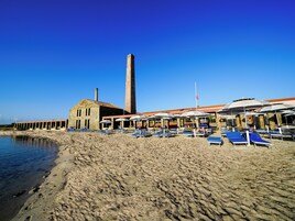 Uma praia privada, espreguiçadeiras, guarda-sóis de praia 