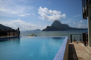 Uma piscina com vista para o mar e montanhas.