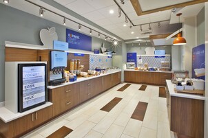 Espaço de café da manhã moderno, com menu digital, diversas opções de comida e design limpo e contemporâneo.