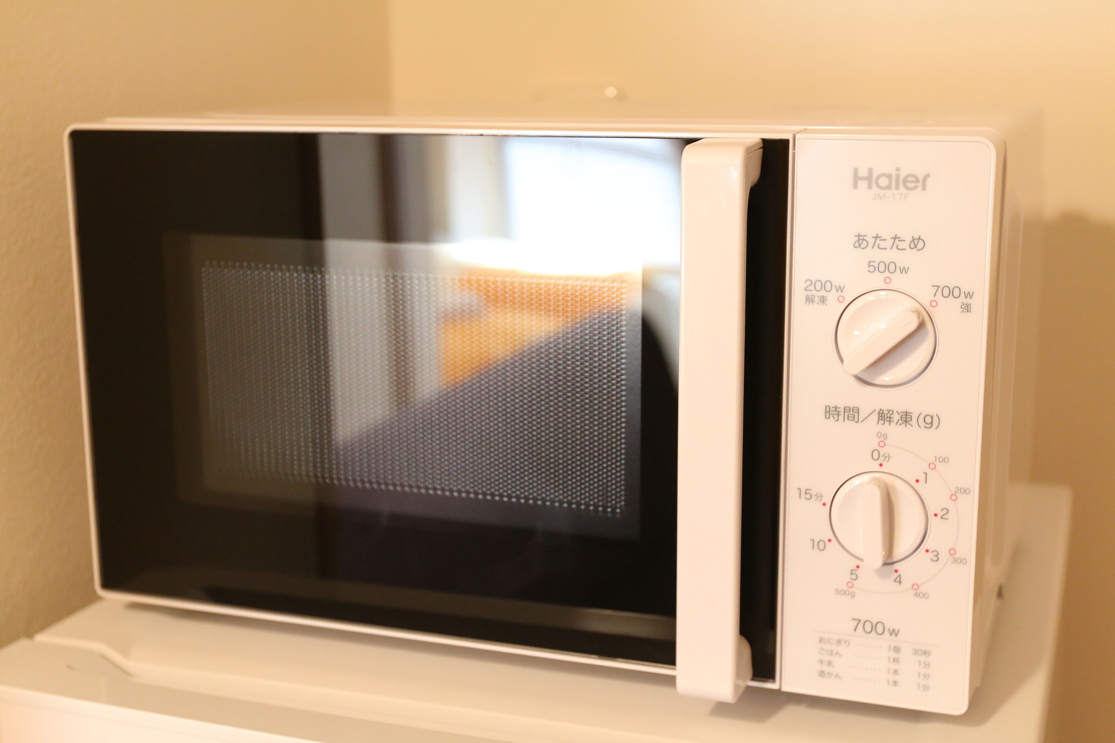 Um micro-ondas branco com visor digital e painel de controle.
