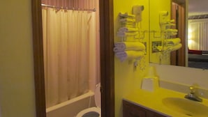 Casa de banho com lavatório amarelo, sanita e cortina de chuveiro.