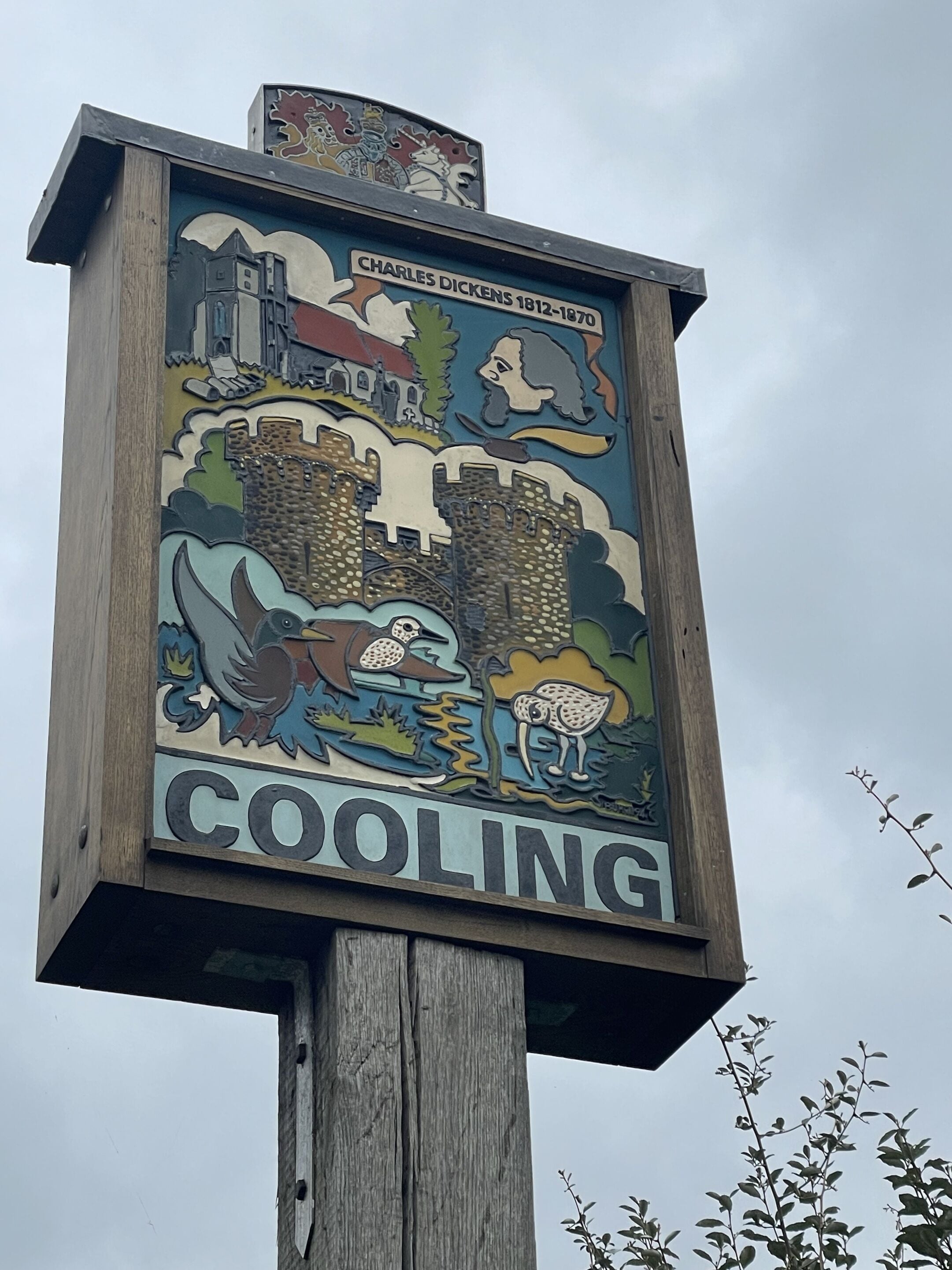 Uma placa de madeira com uma ilustração colorida e a palavra 'COOLING' na parte inferior.