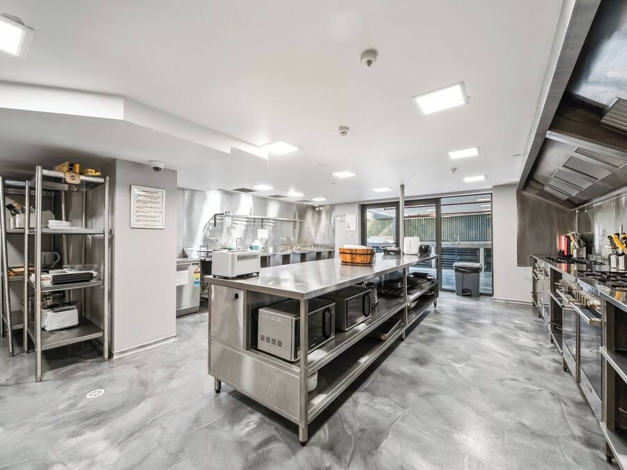 Uma cozinha moderna com eletrodomésticos de aço inoxidável, uma ilha central e vista para a área externa.
