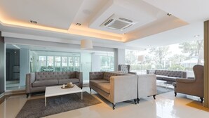 Uma sala de estar moderna com um sofá, poltronas e uma mesa de centro.