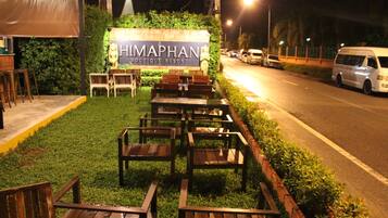 Área externa com mesas e cadeiras, e placa indicando 'HIMAPHAN BOUTIQUE RESORT'.