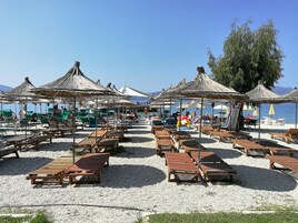 Na praia, espreguiçadeiras, guarda-sóis de praia 