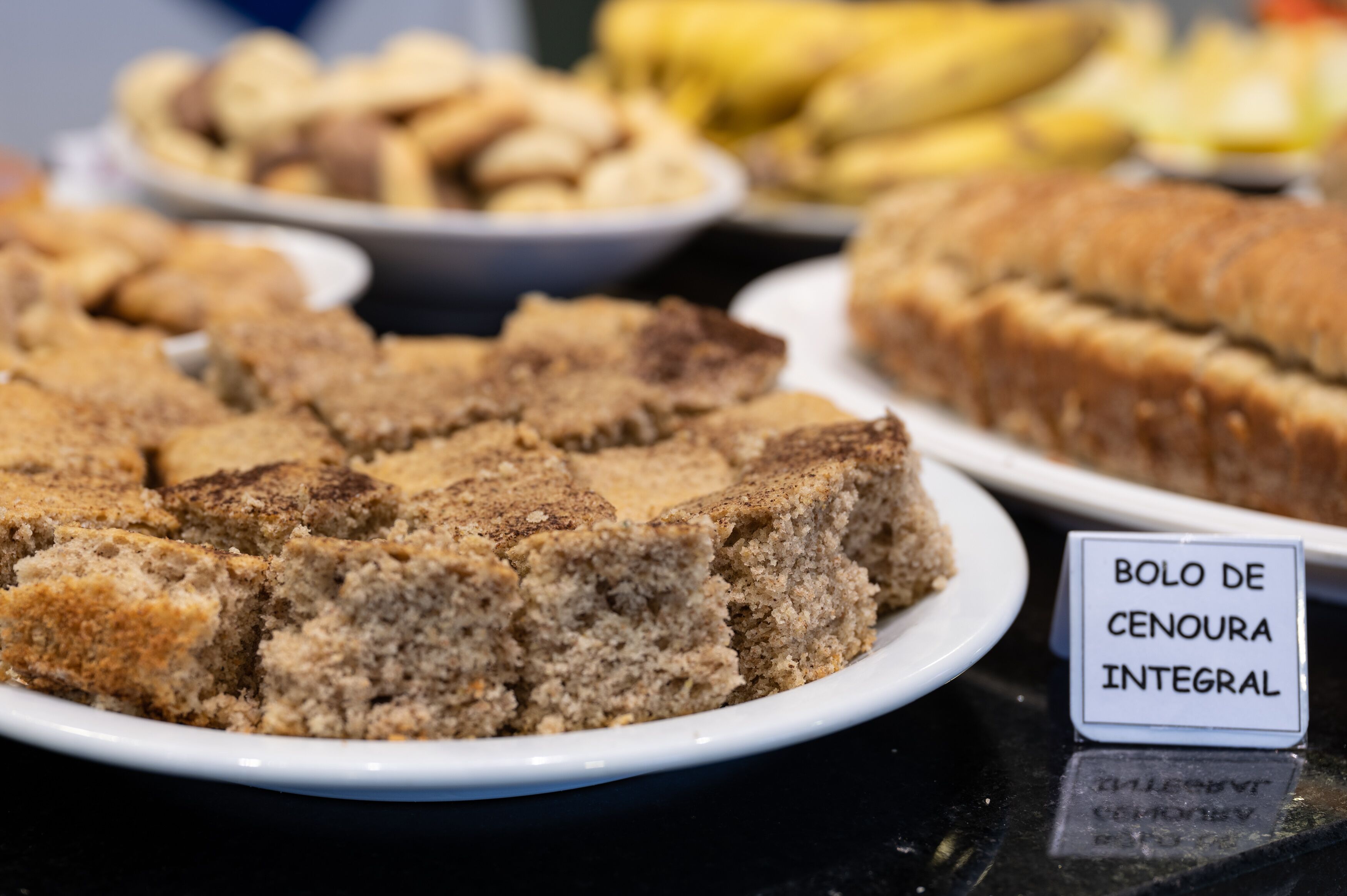 Um prato de bolo de cenoura integral com uma placa indicando o nome.