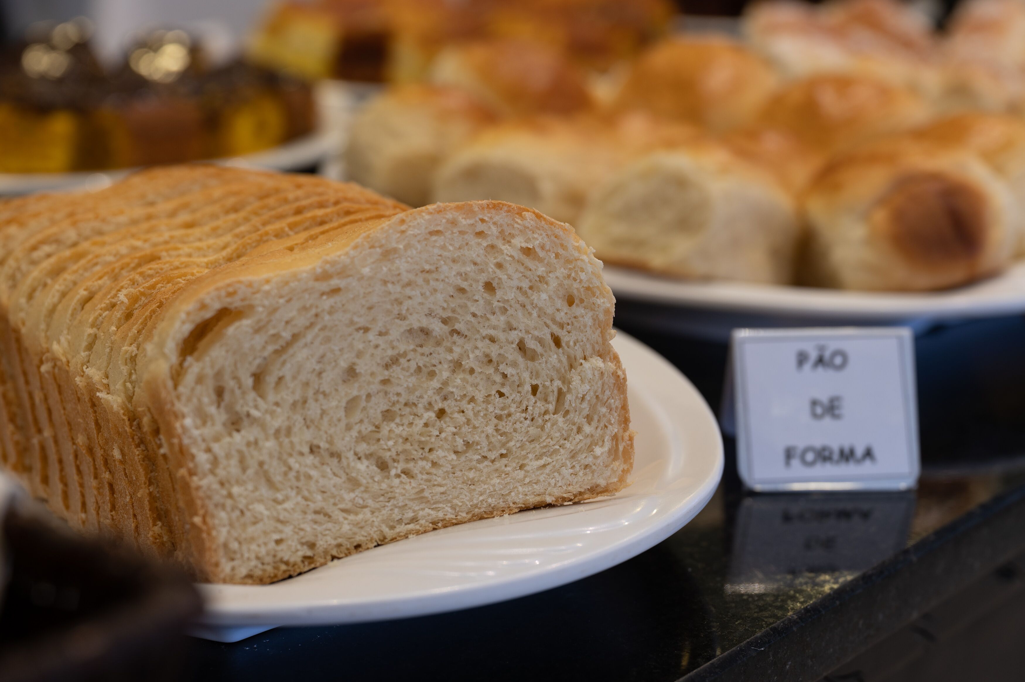 Uma fatia de pão numa placa com a inscrição 'Pão de Forma'.