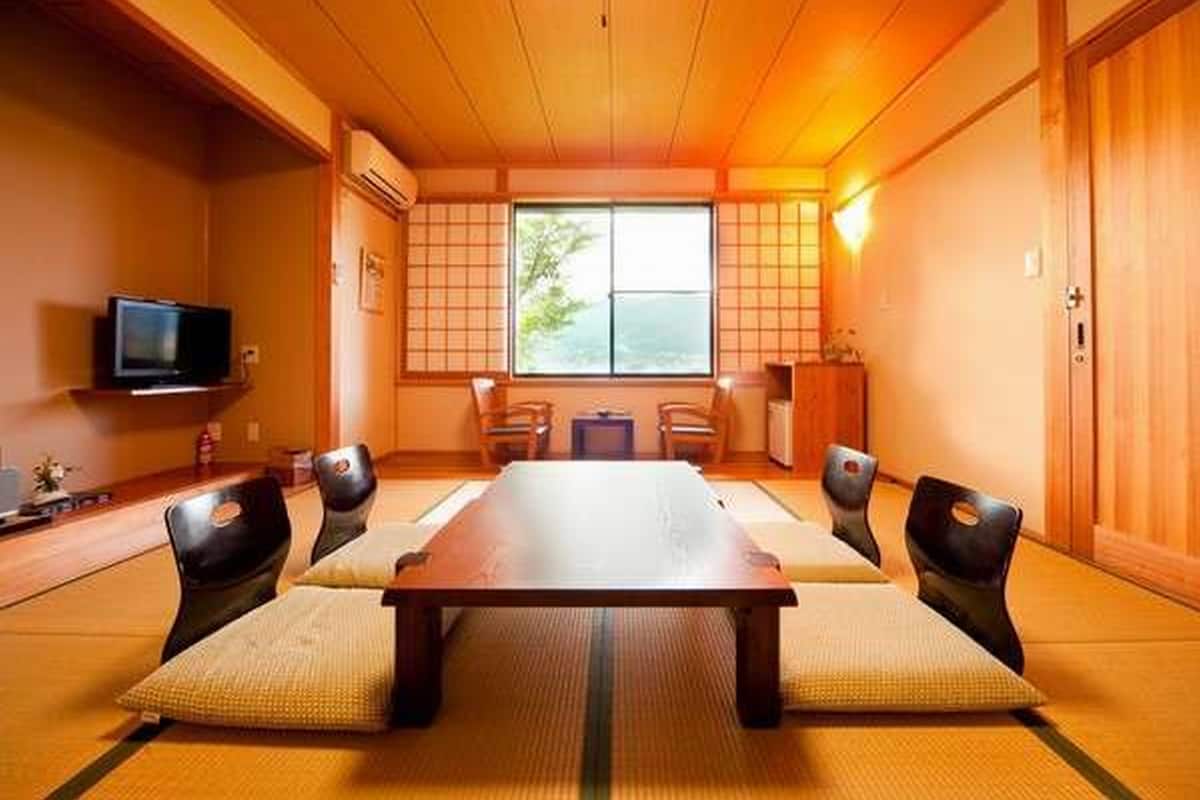 Um quarto tradicional japonês com tatame, uma mesa baixa e biombos shoji.