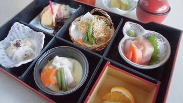 Uma lancheira bento com diversos alimentos, incluindo sushi, legumes e frutas.
