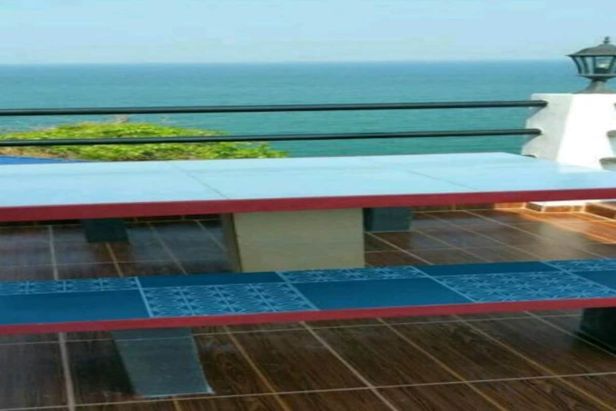 Terraço com vista para o mar, guarda-corpo e poste de iluminação.