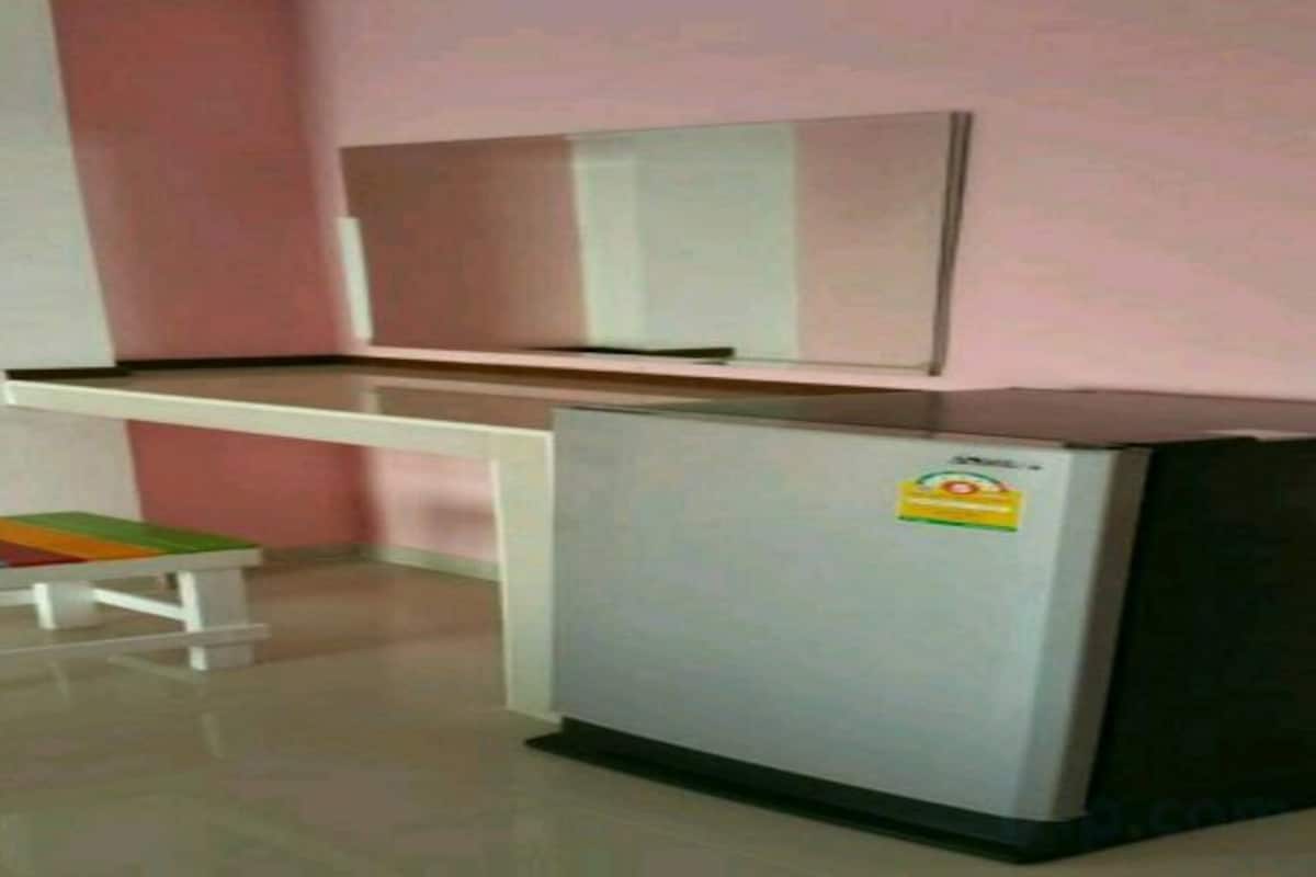 Uma cozinha compacta equipada com geladeira, micro-ondas e bancada.