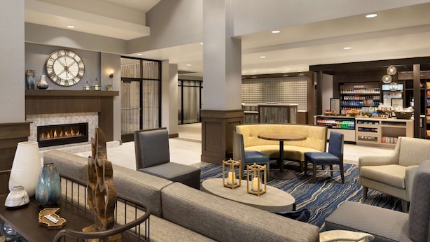 Um saguão de hotel com lareira, área de estar e minibar.