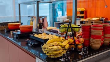 Balcão de buffet com diversas frutas e placa indicando a seção de frutas.