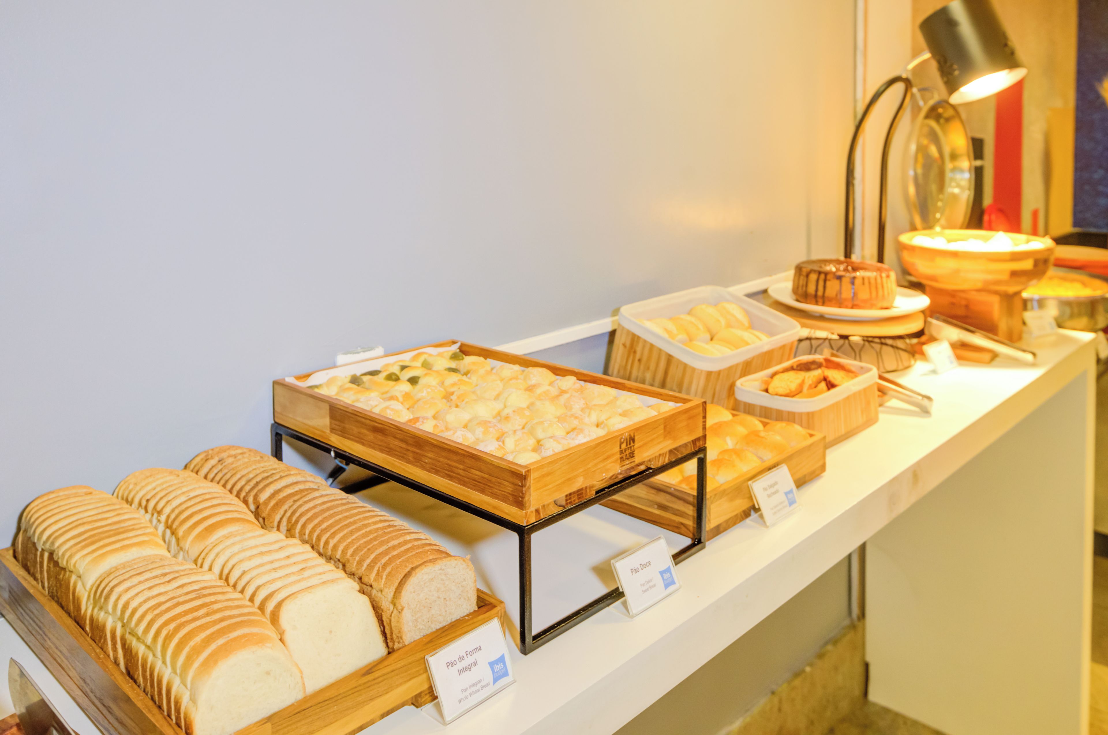 Um buffet com diversos pães e doces.