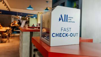 Sinal de check-out rápido com o texto 'All accor live limitless' numa caixa branca.
