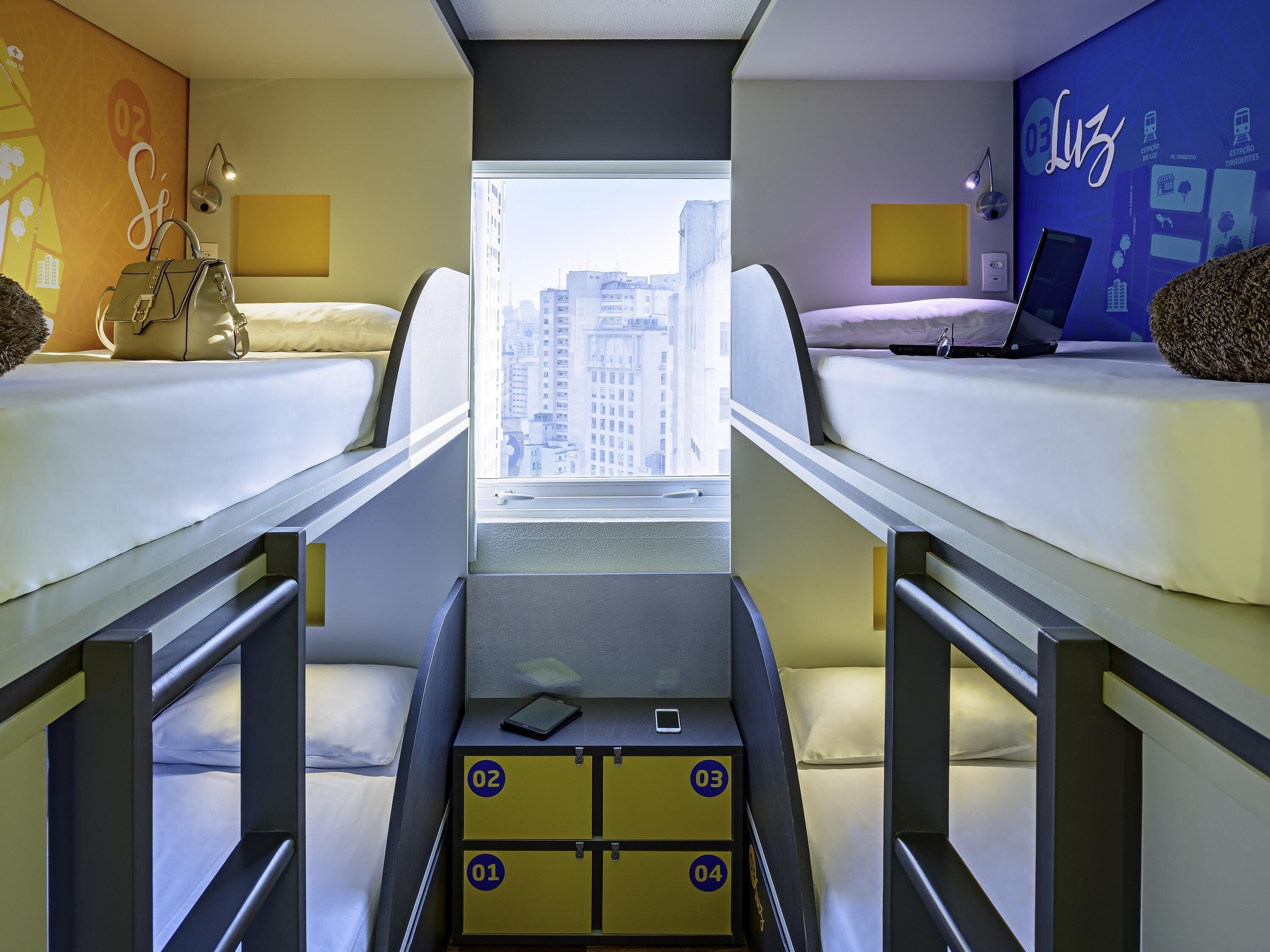 Quarto de hotel com duas camas, vista para a cidade e uma parede com uma sequência numérica.
