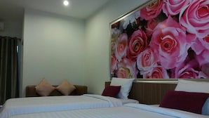 Quarto de hotel com duas camas, uma grande obra de arte floral na parede e uma cabeceira marrom.