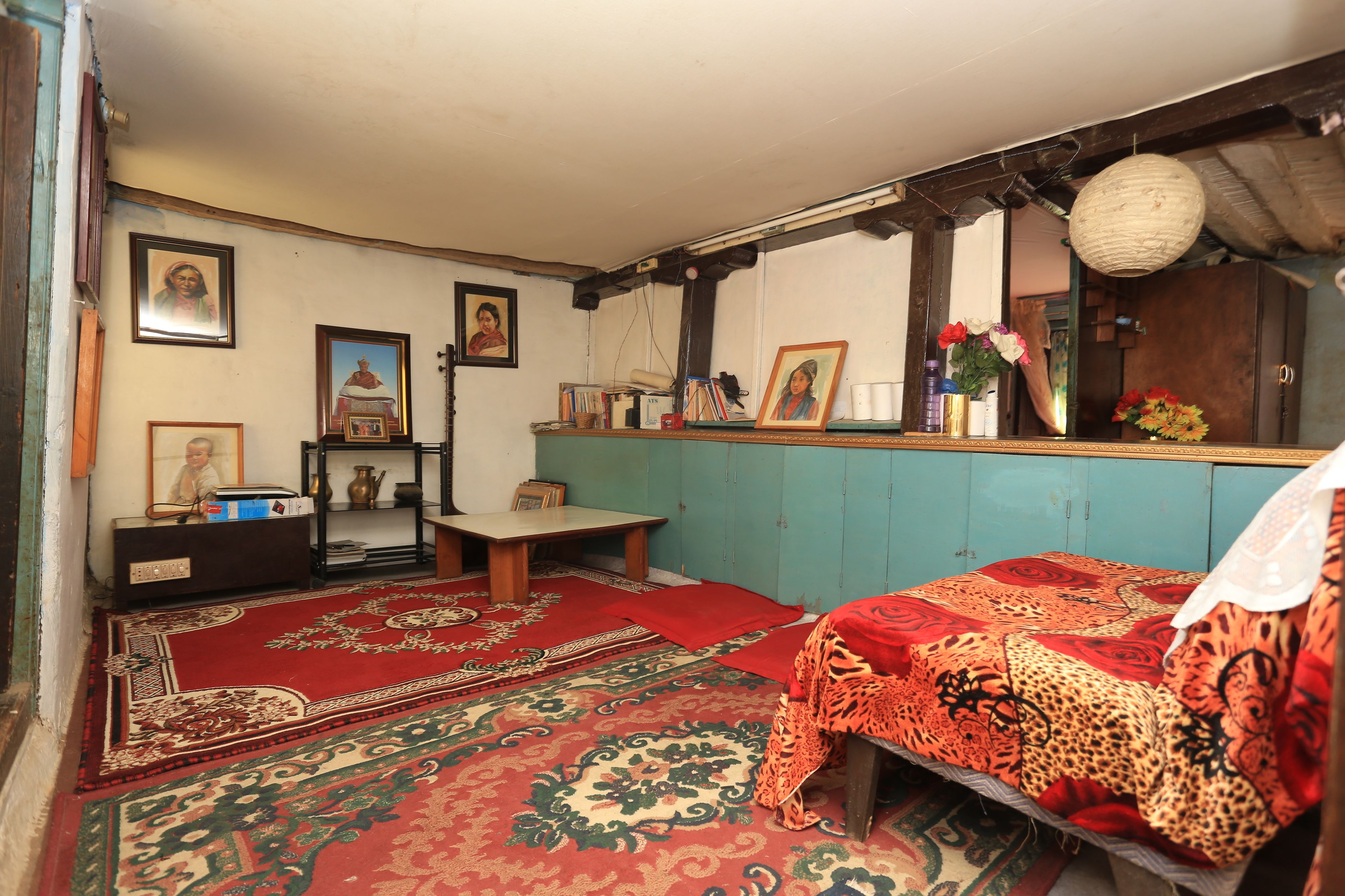 Quarto tradicional com uma cama, uma mesa de madeira e um espelho.
