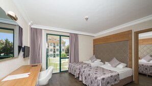 Quarto de hotel com duas camas, uma escrivaninha e uma cadeira.