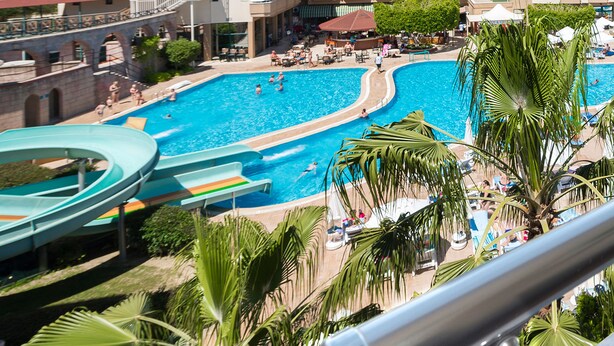 Um hotel com várias piscinas, incluindo uma piscina central ampla e um toboágua.