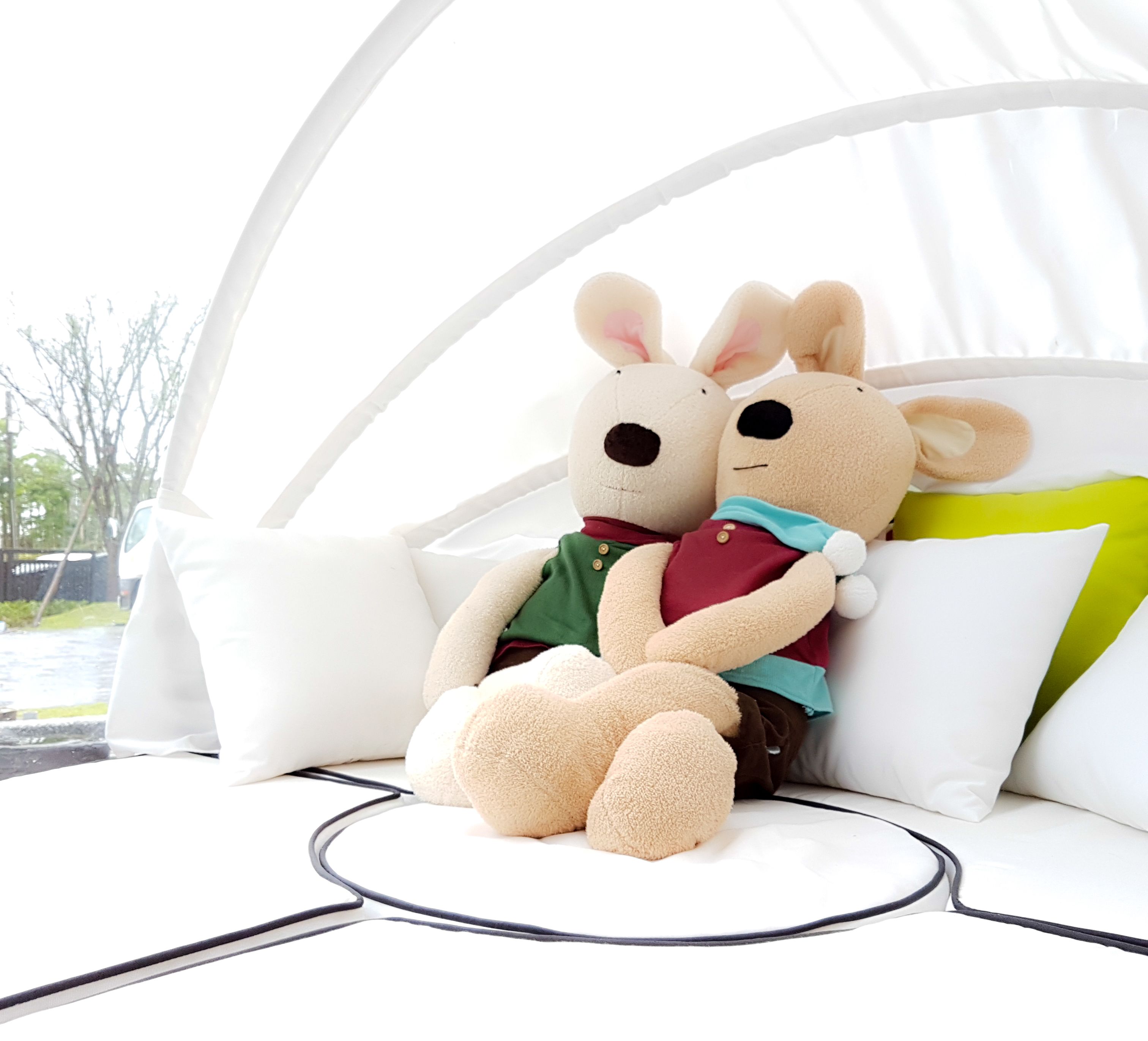 Um sofá branco com brinquedos macios em um ambiente acolhedor.