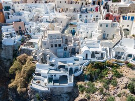 Vila caiada com edifícios em terraços, ruas estreitas e uma escadaria central.