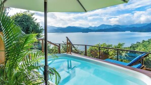 Uma área de piscina com vista para um lago e montanhas.