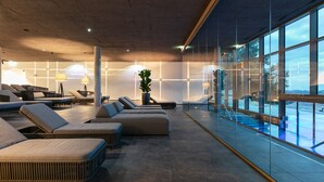 Uma área de estar moderna com assentos e uma escada que dá acesso a uma área externa.