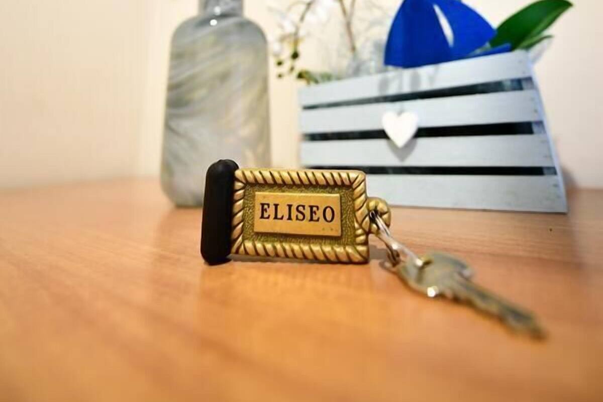 Um chaveiro com o nome "ELISEO" sobre uma superfície de madeira.