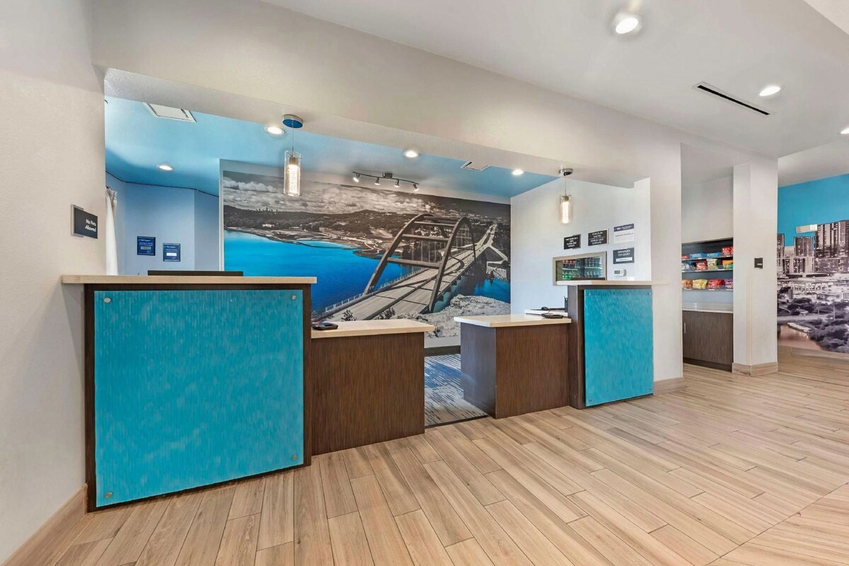 Uma área de recepção com um grande mural, balcões de madeira e design de interiores moderno.