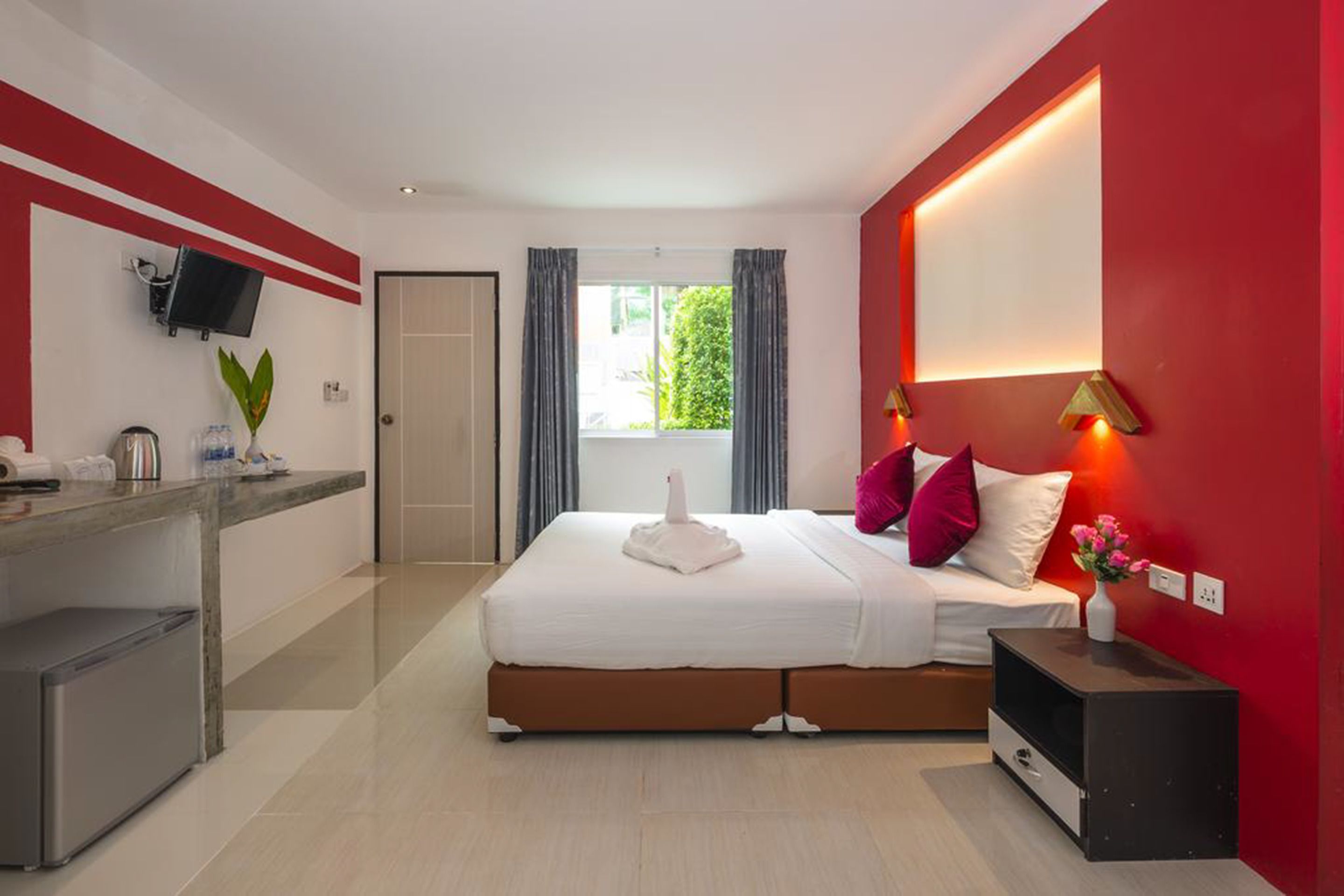 Quarto de hotel moderno com cama, mesa de cabeceira, televisão e vista para o exterior.