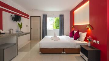 Quarto de hotel moderno com cama, mesa de cabeceira, televisão e vista para o exterior.