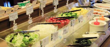 Buffet com diversas opções de comida e utensílios.