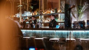 Uma área de bar com vários bancos e balcão.