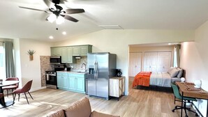 Um apartamento moderno com cozinha, sala de jantar e quarto.