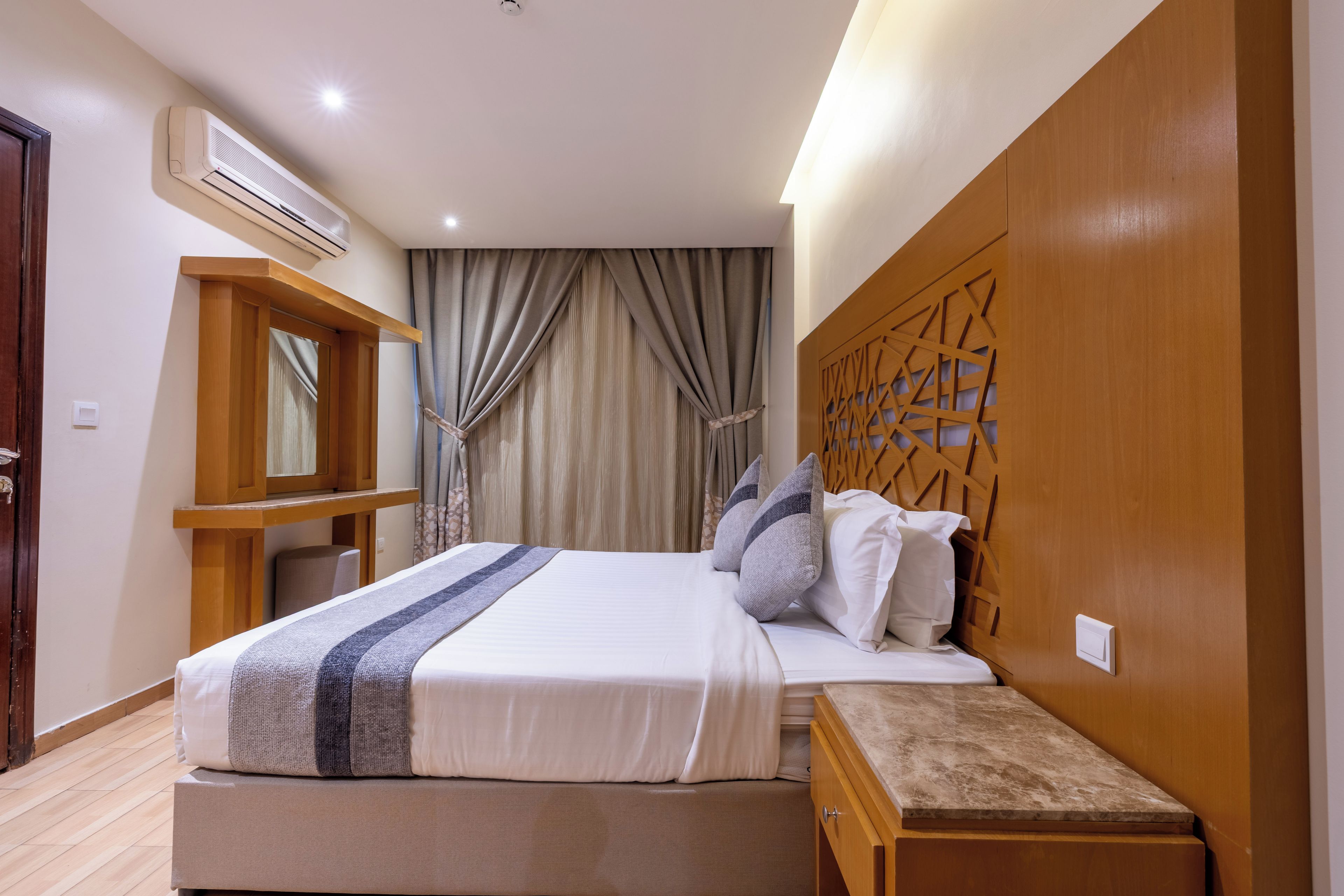 Quarto de hotel com cama, mesa de cabeceira e ar condicionado.